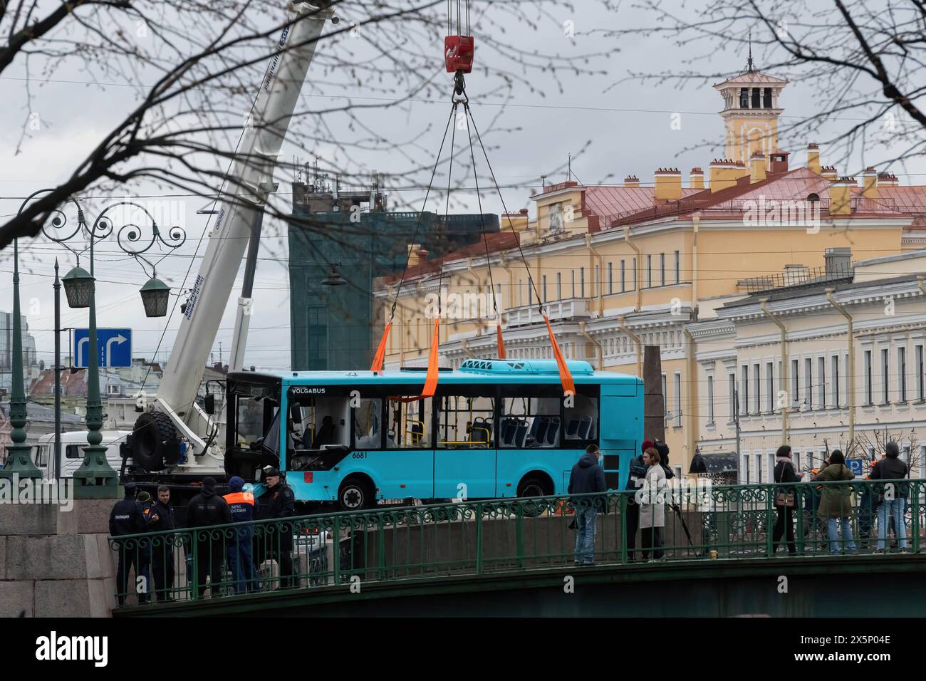 Specialists are lifting the bus that fell from the bridge out of the ...