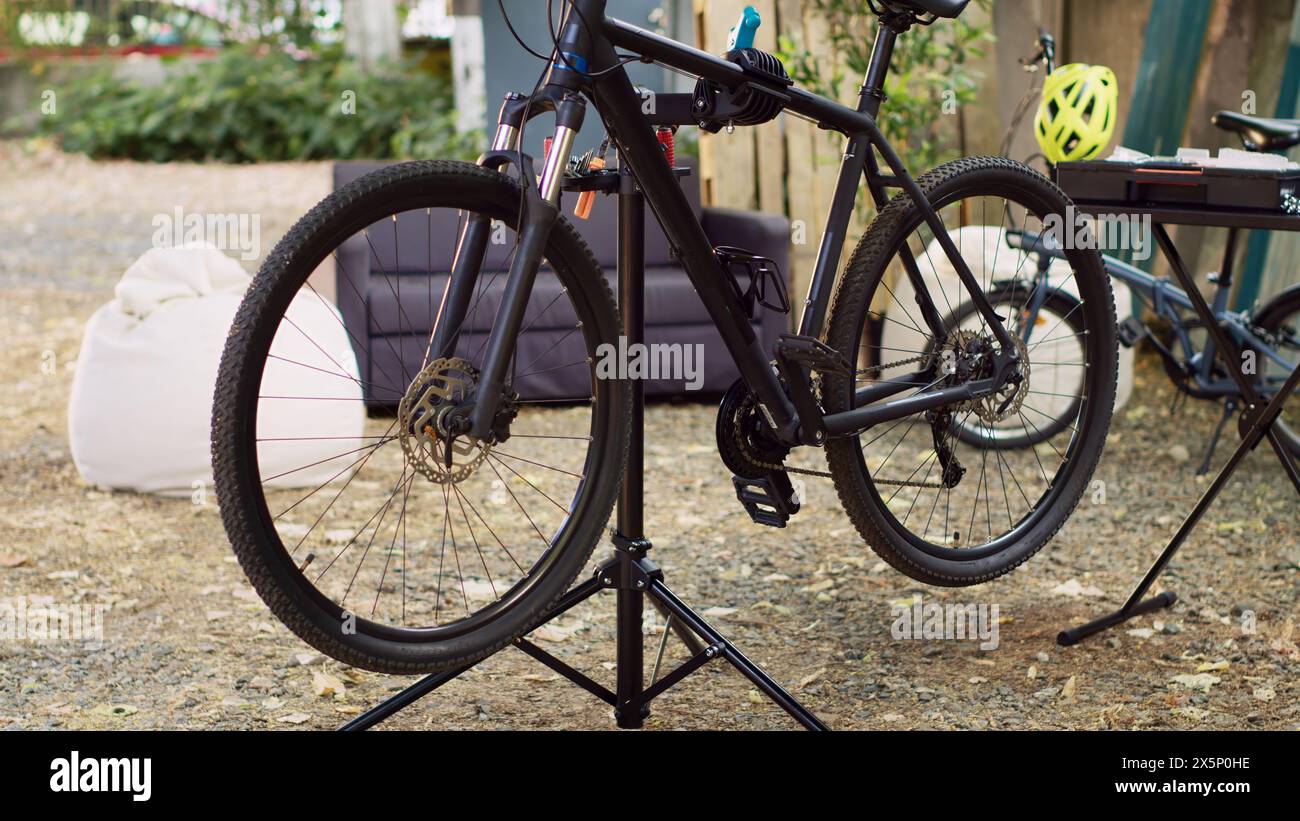 Modern bicycle is visible in the yard positioned on repair-stand for ...