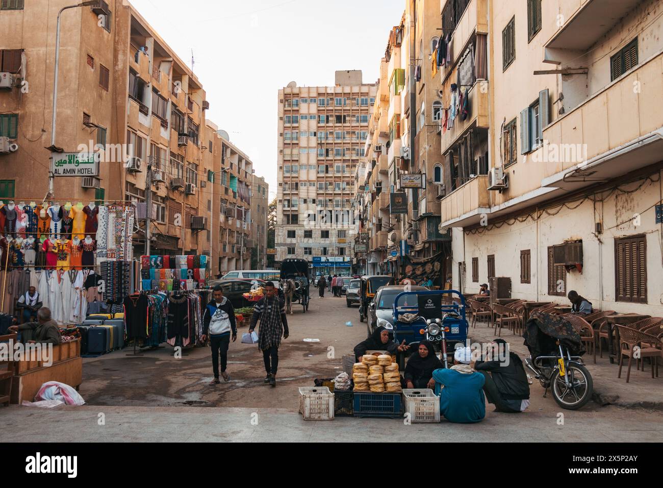 a residential street with apartment blocks and people selling bread and ...