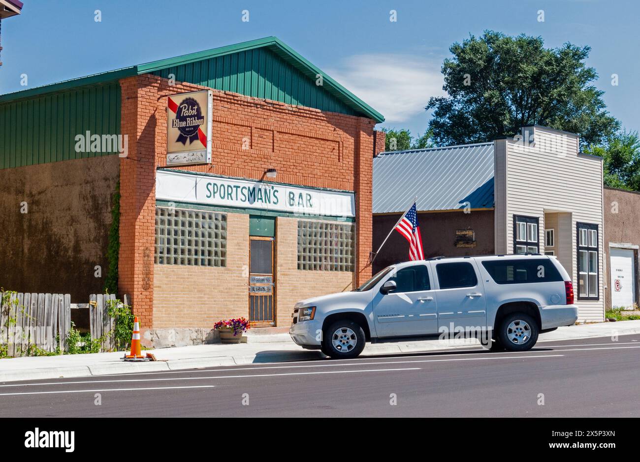 White Chevy Suburban truck parked in front of the Sportsman's Bar ...