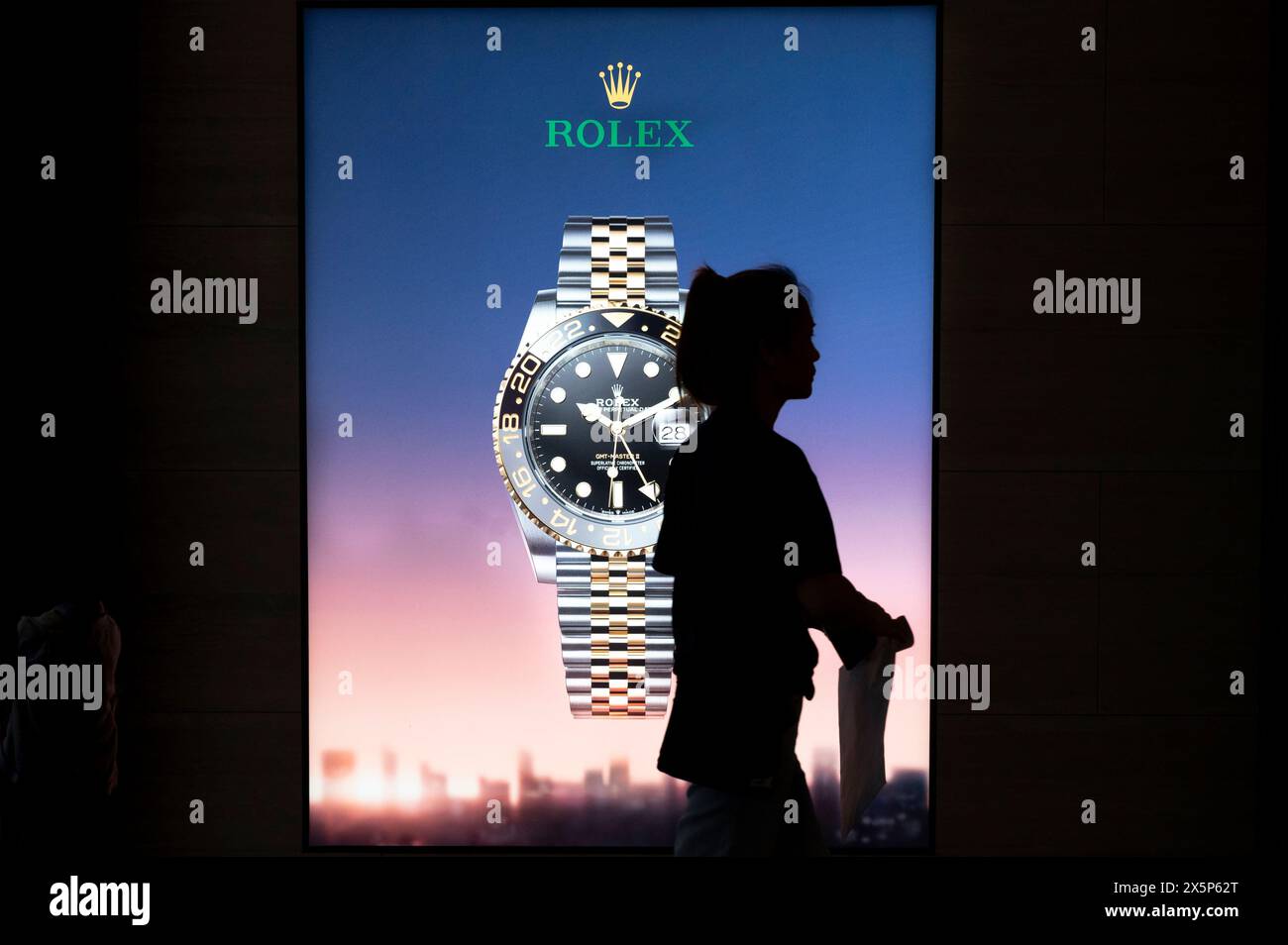 A pedestrian walks past a street commercial ad from the Swiss luxury ...