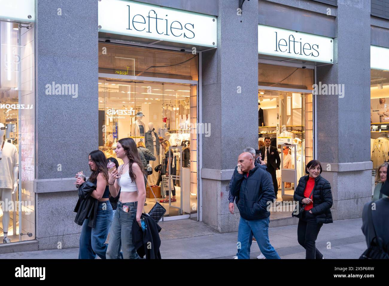 Pedestrians walk past the Spanish fashion brand owned by Inditex ...