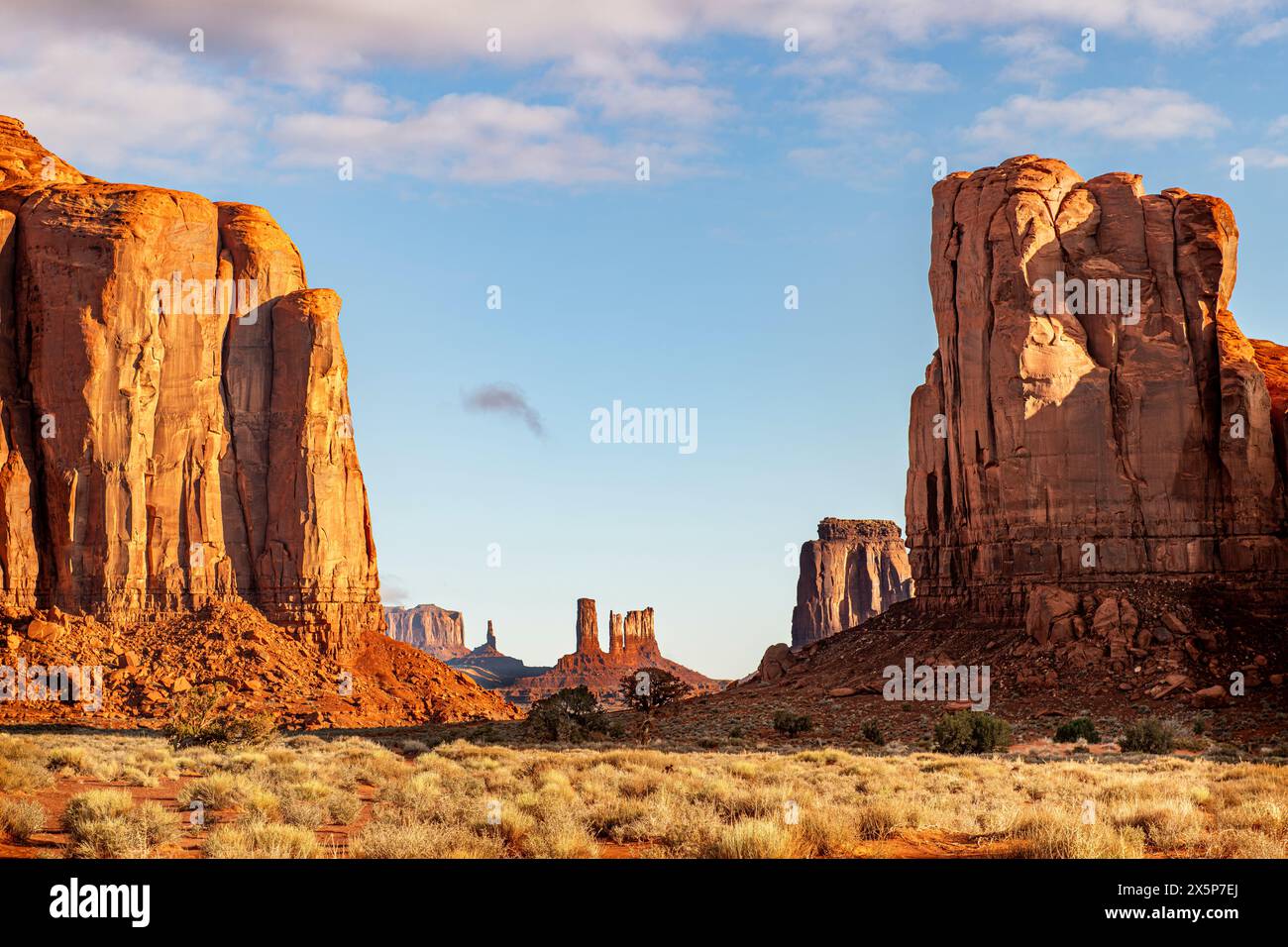Mountainside lit up by a rising sun casts an orange color against the ...