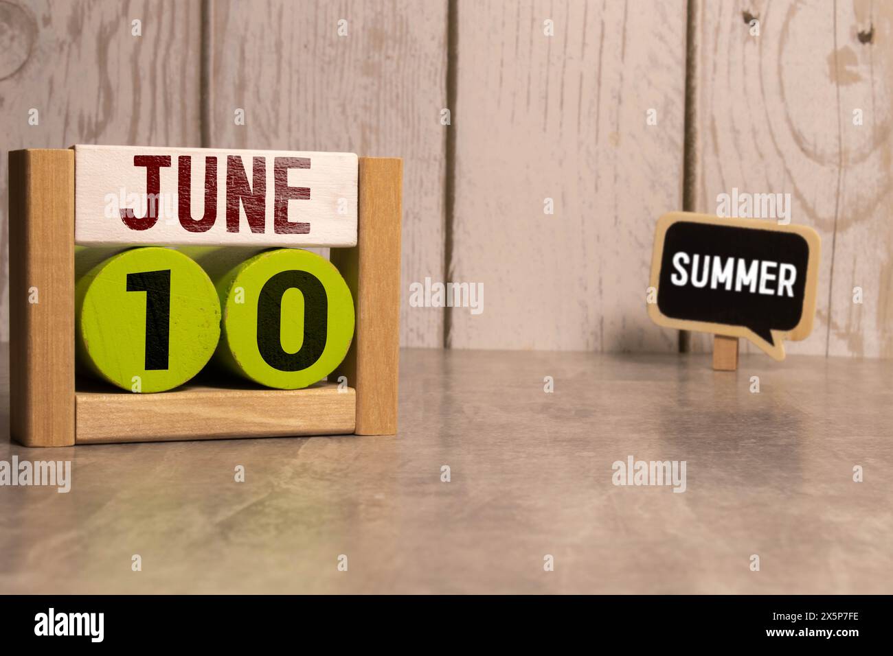 June 10 calendar date text on wooden blocks with blurred nature ...