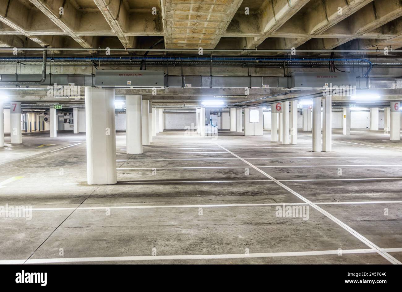 empty paid underground car parking, concrete poles artificial cool neon ...