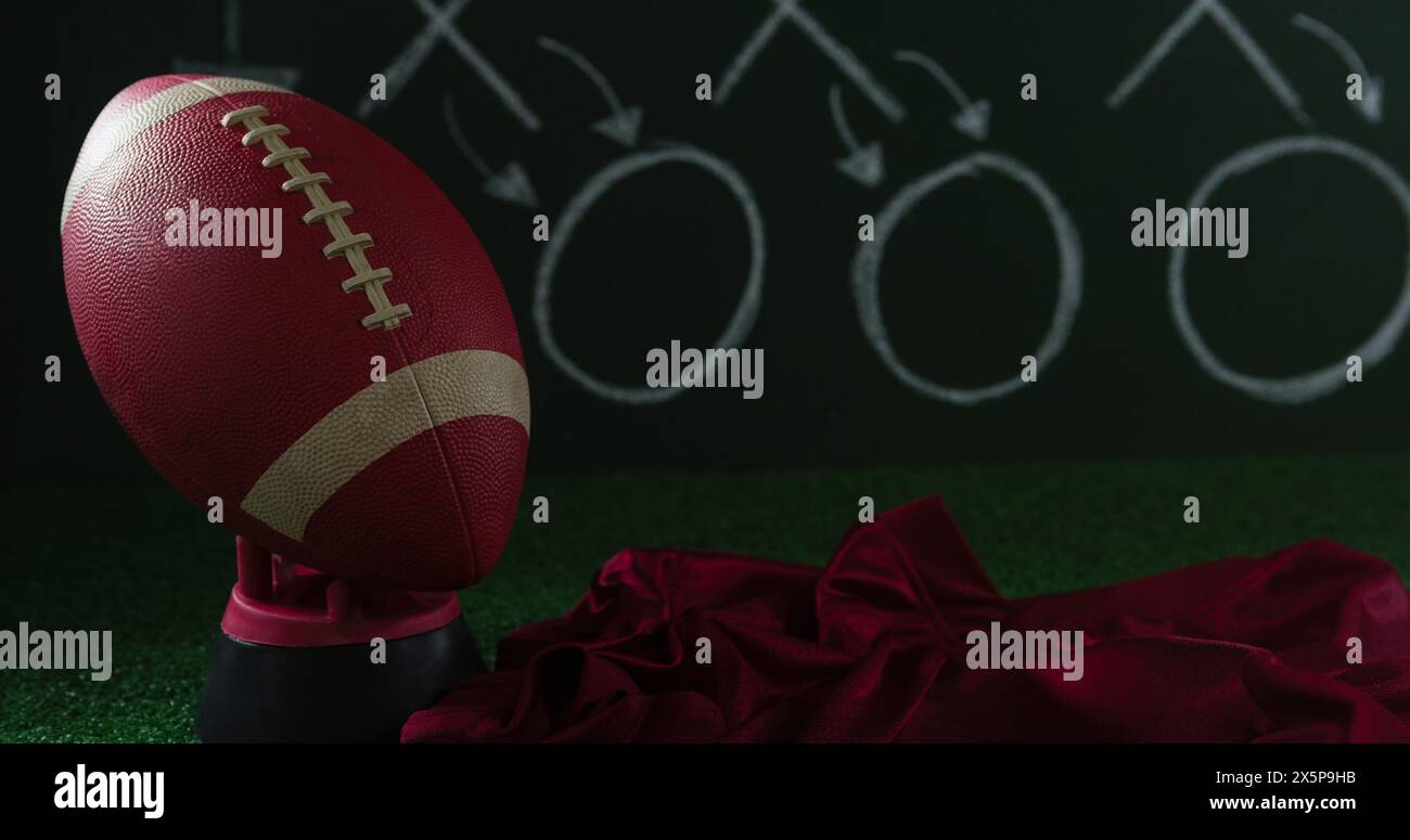 Football on stand, red cloth close, strategies on chalkboard behind ...