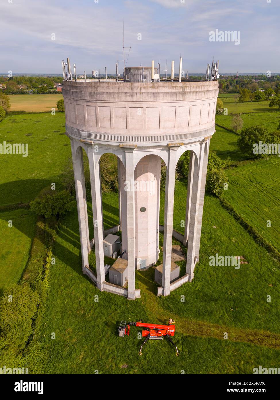 Drone shot of an imposing water tower and a fire truck parked below ...