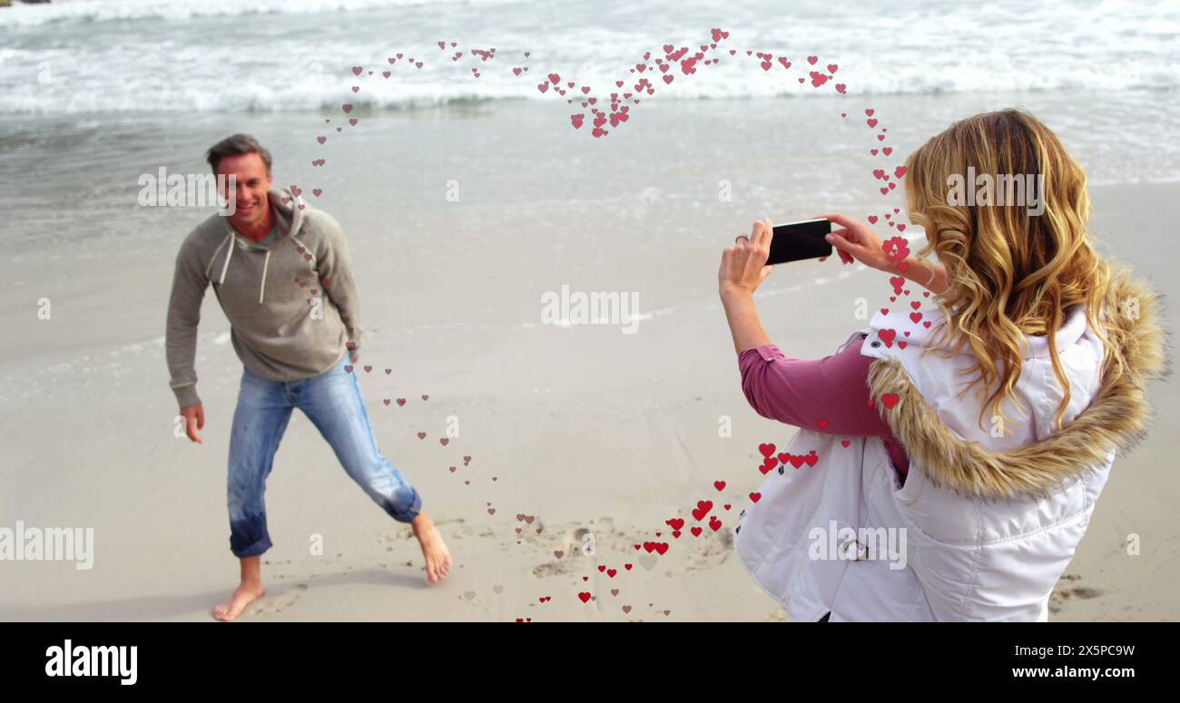 Image of small hearts forming heart over caucasian woman filming ...