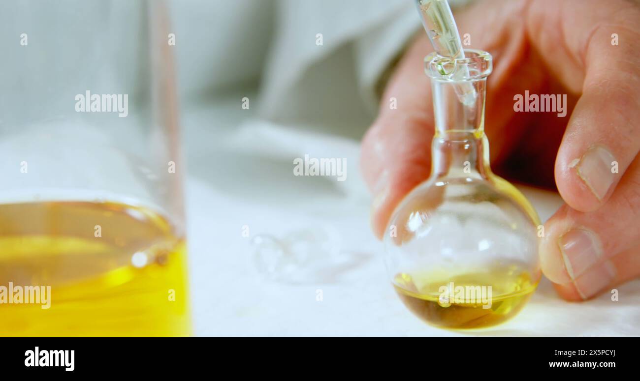 Image of german over caucasian male scientist pouring liquid into ...