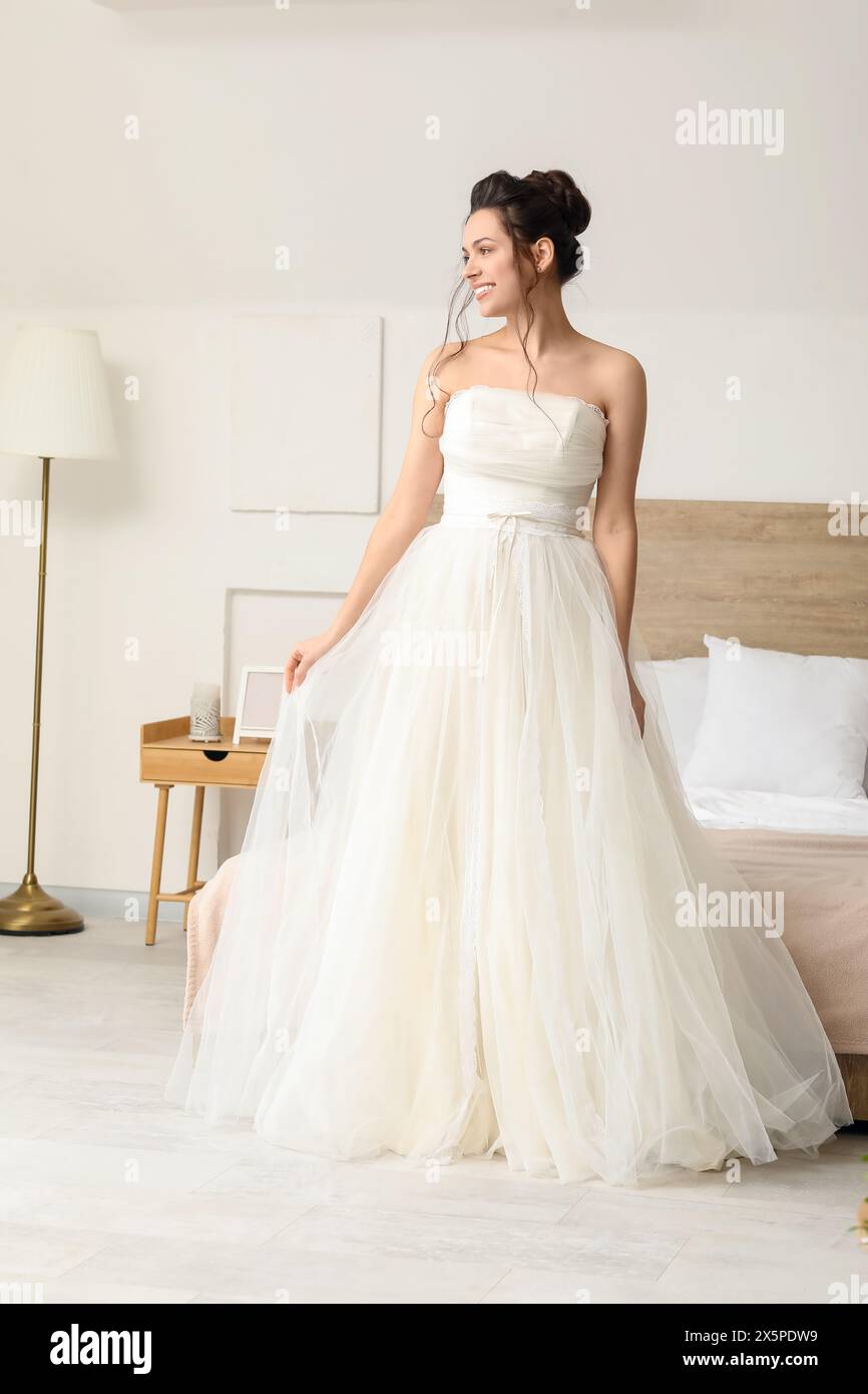 Young bride wearing her wedding dress in bedroom Stock Photo - Alamy