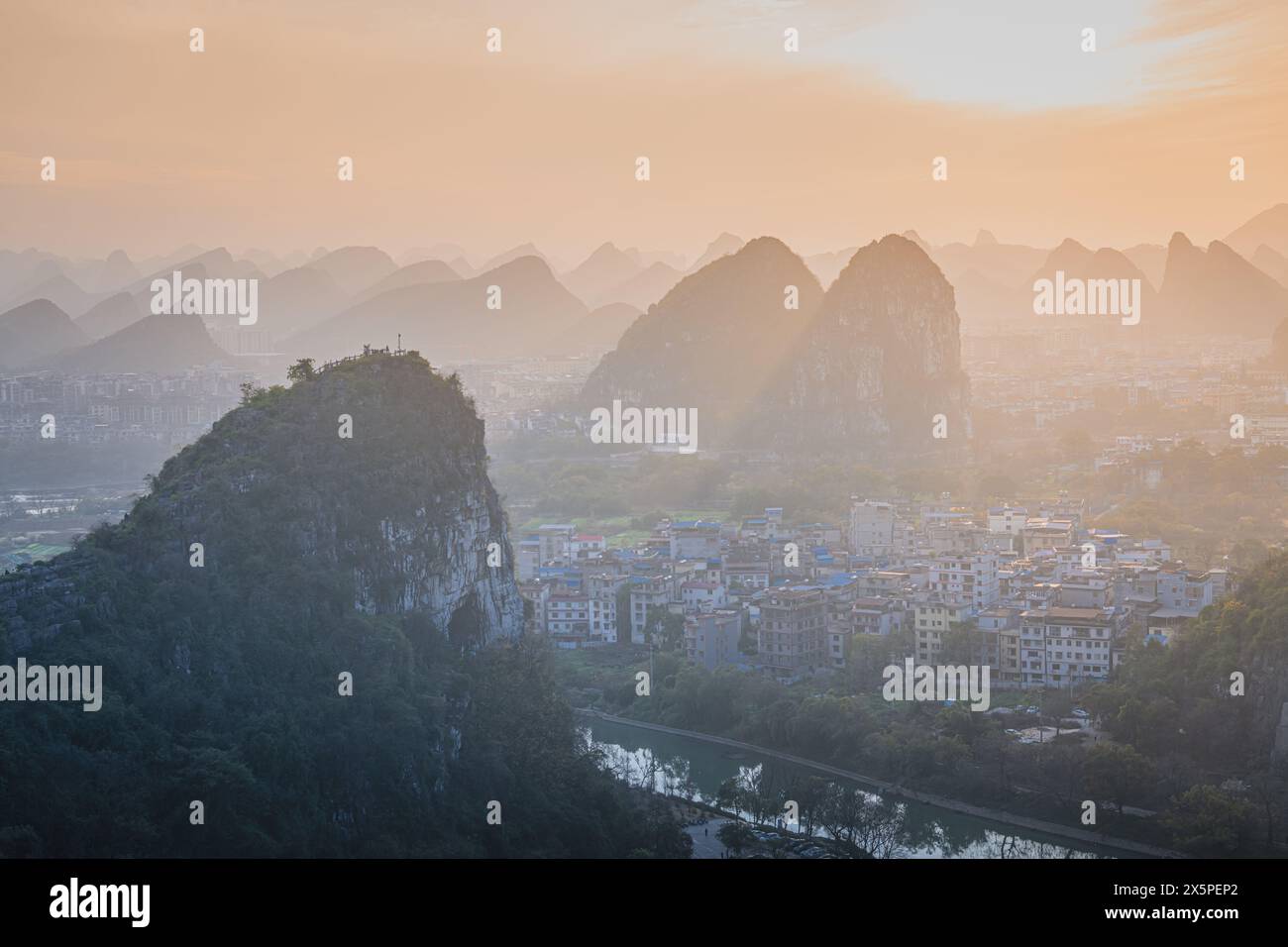 Limestone mountains at the sunset surrounded by the city buildings ...