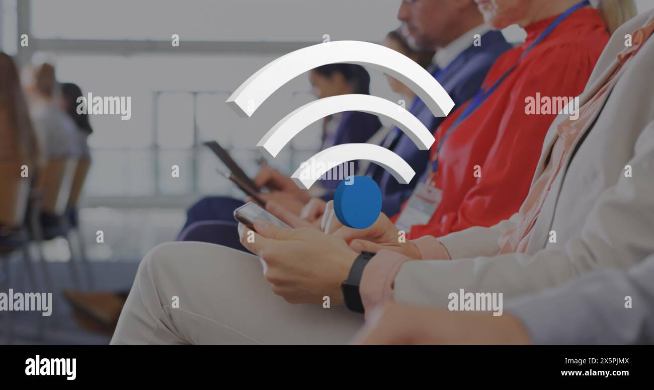 Image of wifi icons over diverse business people using electronic ...
