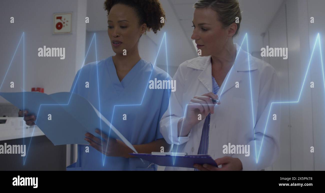 Image of heart rate monitor over diverse female doctor and health ...