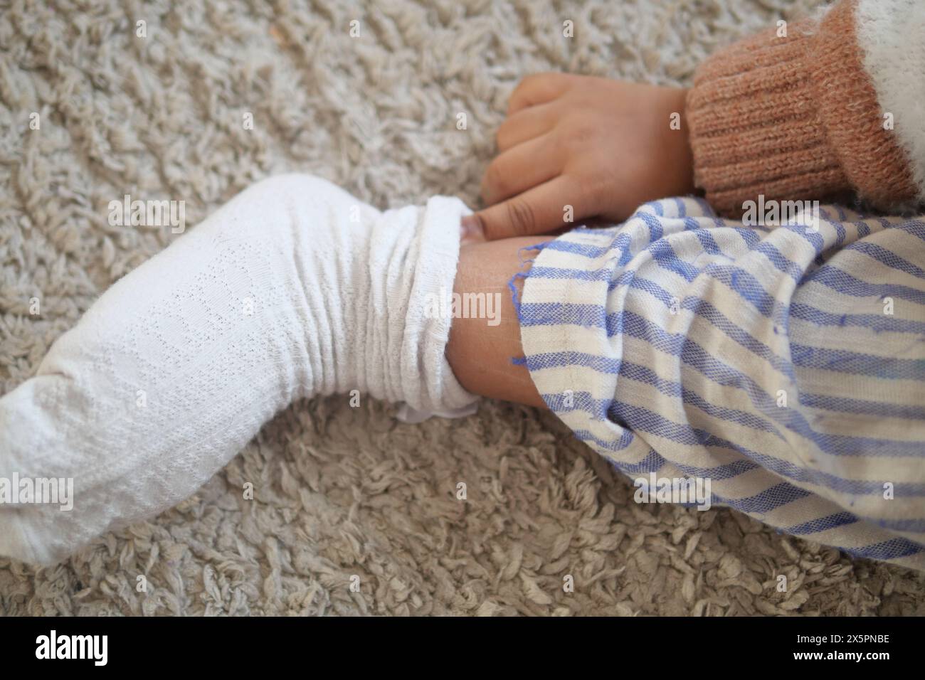 a little girl trying to take off her socks Stock Photo - Alamy