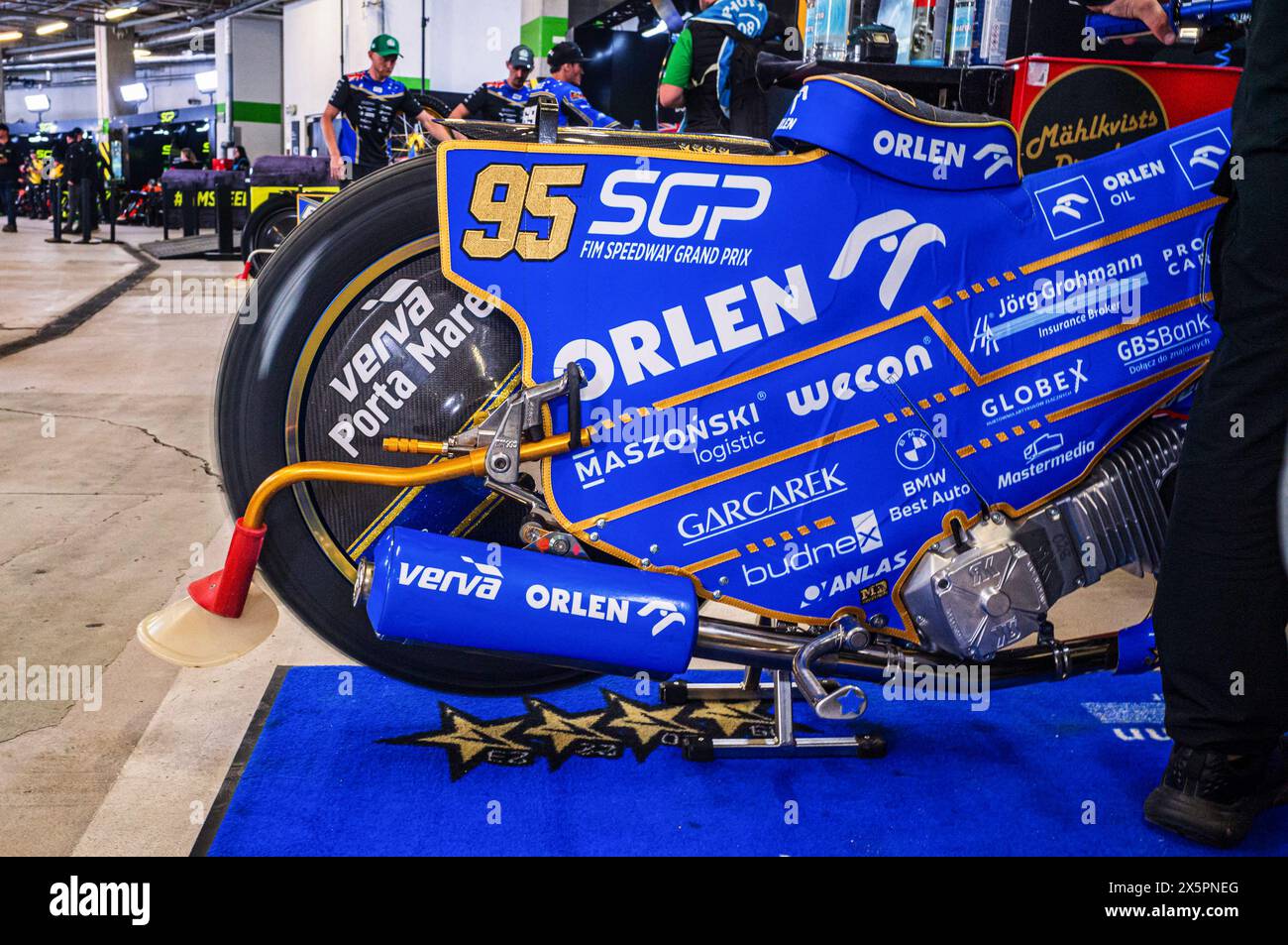 A mechanic warms up the engine of the bike belonging to Polish rider ...