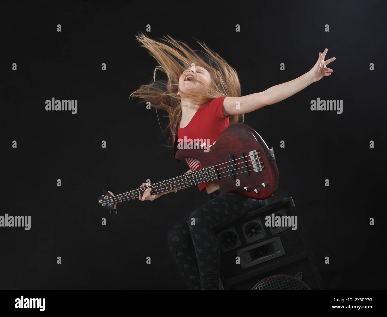 cheerful little girl playing bass guitar on black background Stock ...