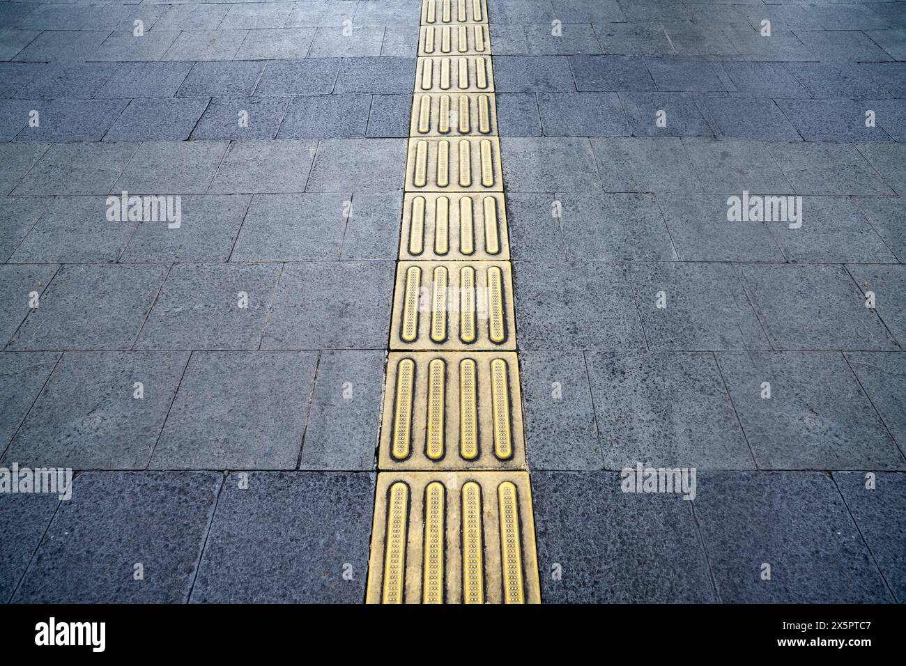 Footpath with yellow tactile paving for blind people walking safely on ...