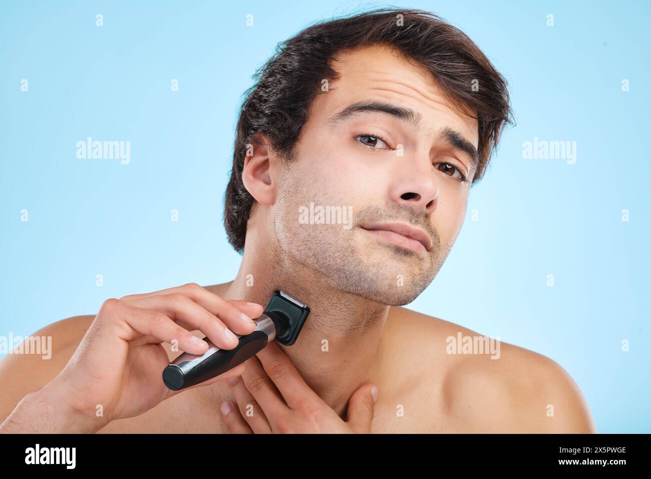 Man, shaving and face with electric razor on studio backdrop for ...