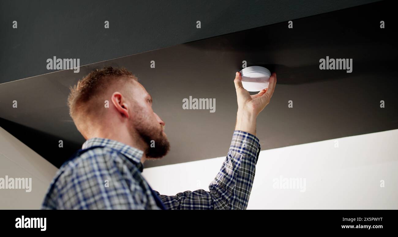 Installing Smoke Detector On Ceiling At Home Stock Photo - Alamy