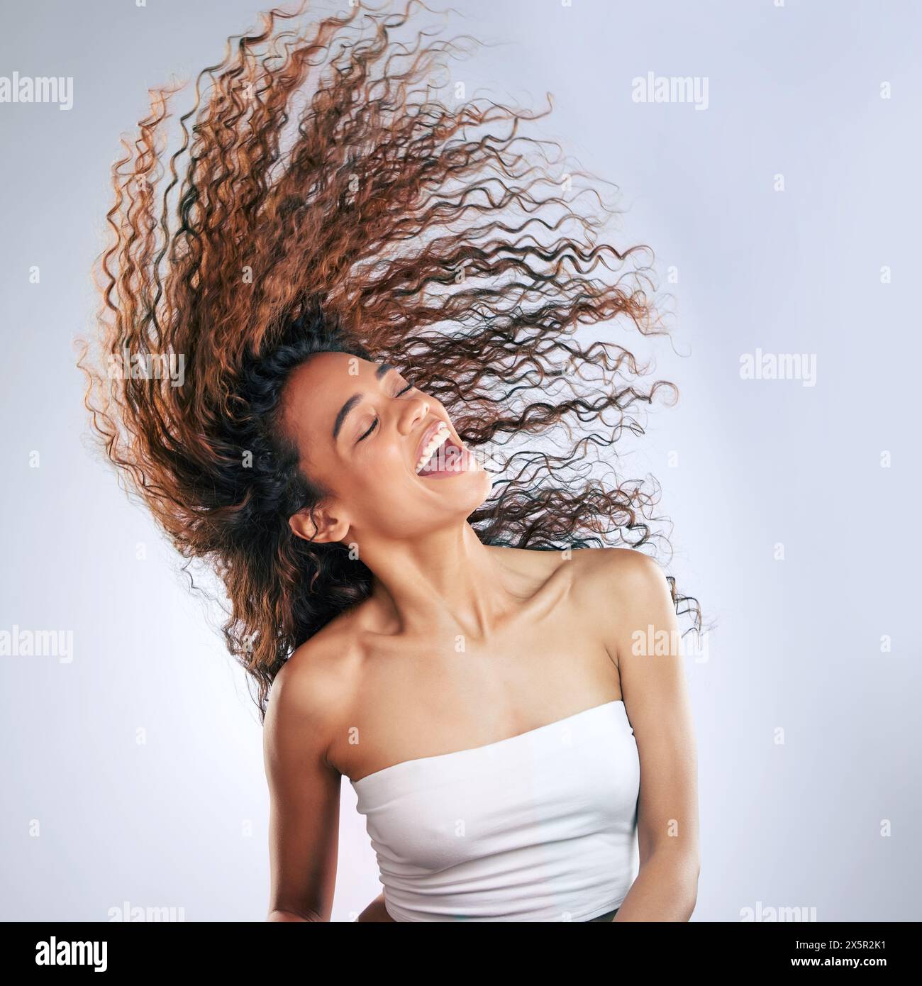 Woman, flip and hair in studio happy for healthy, volume and natural ...
