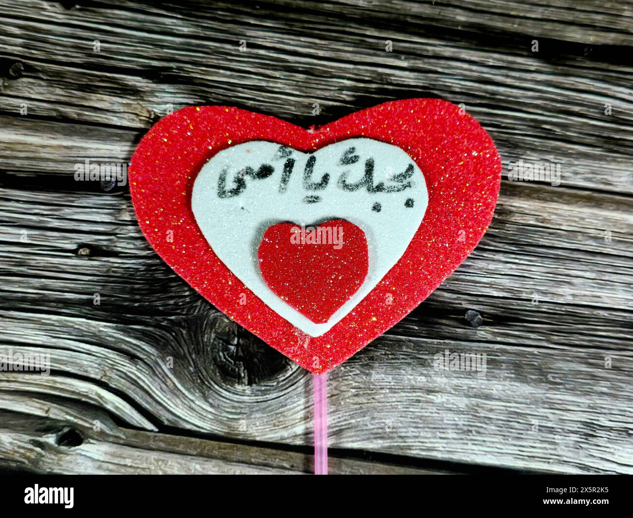 Translation of Arabic text (I love you mom), in a heart shaped red ...