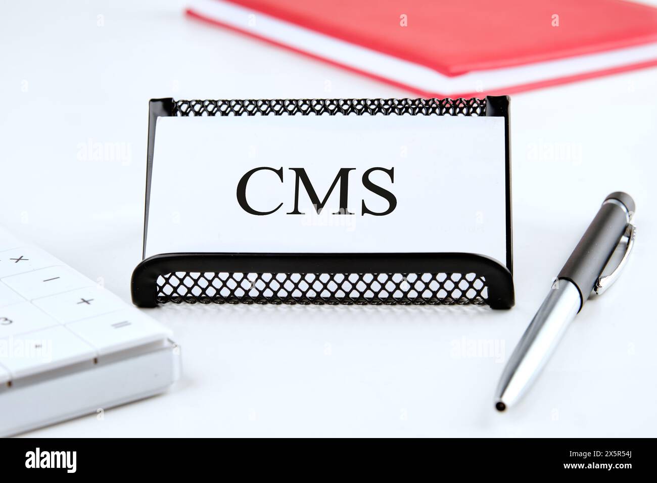 CMS (Custom Management System) written on a business card on a white ...