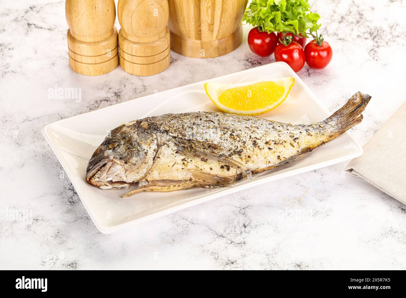 Baked Dorado fish served lemon slice Stock Photo - Alamy