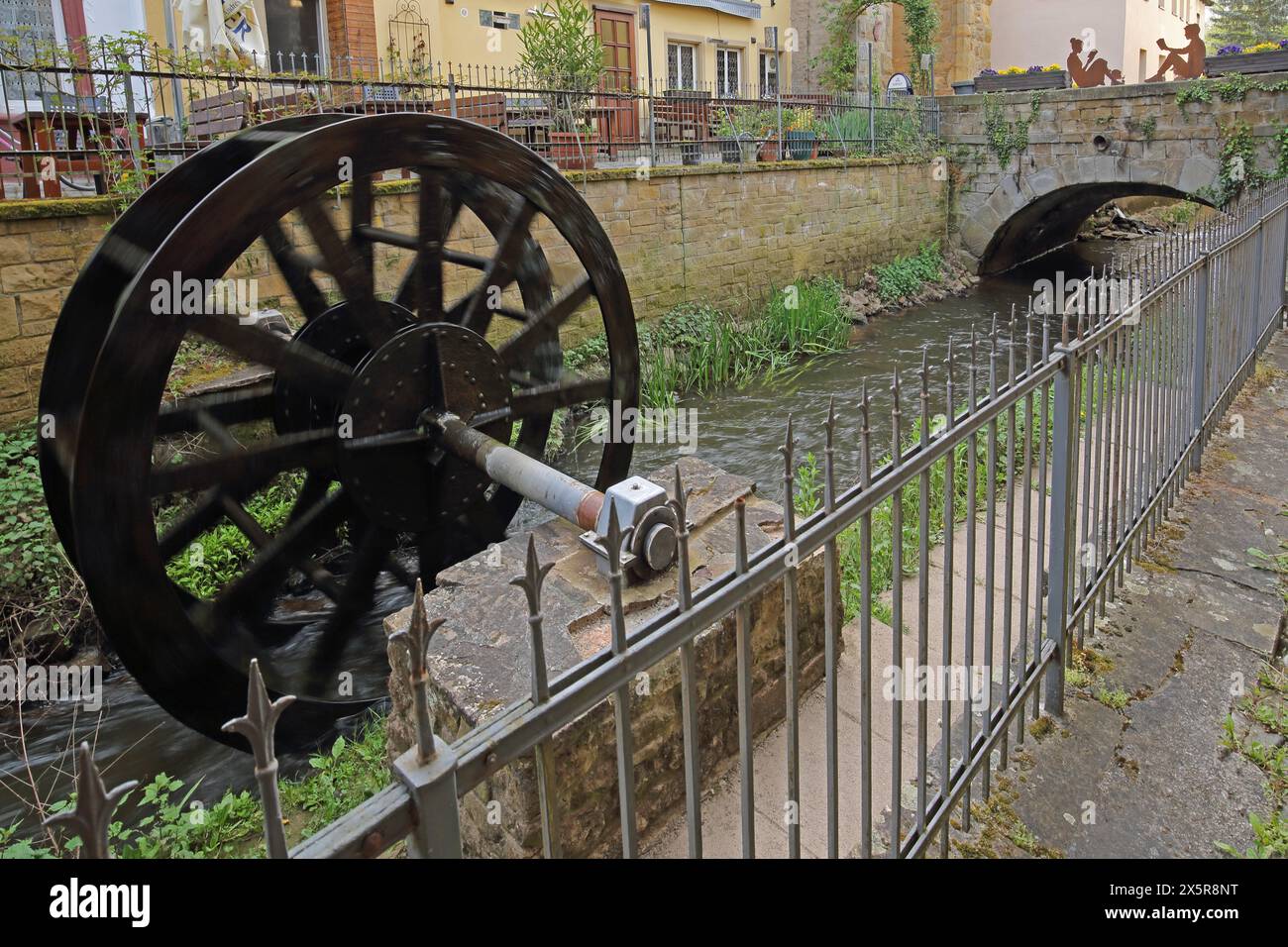 Water wheel at stream casting with metal fence, idyll, motion blur ...