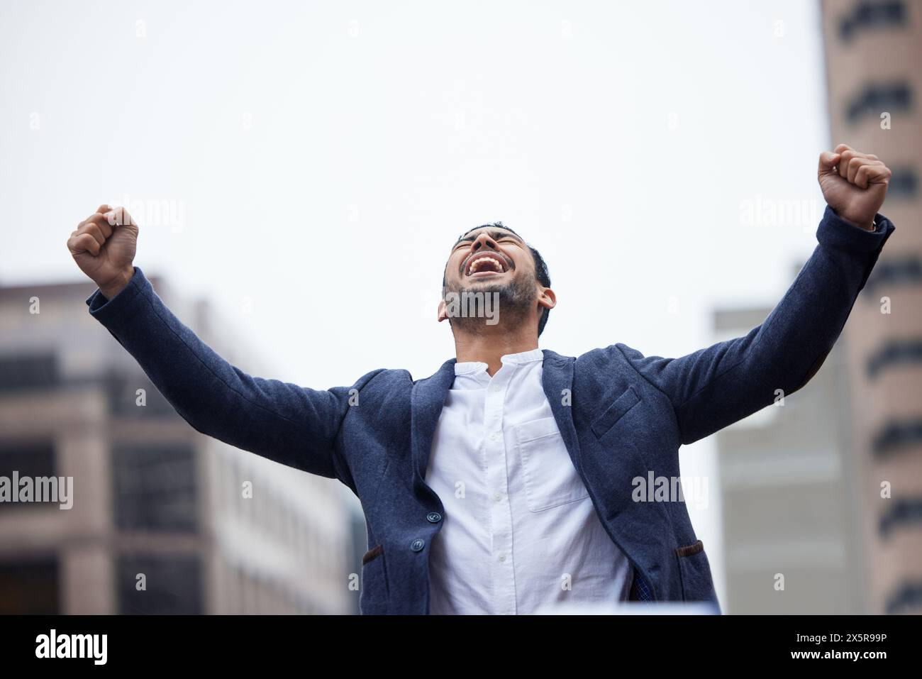 Businessman, happy and celebration for success in city with arms up for ...