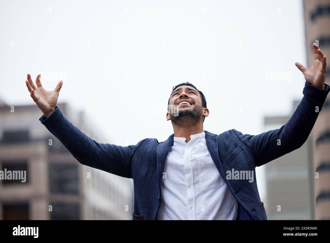 Businessman, happy and celebration for success in city with arms up for ...