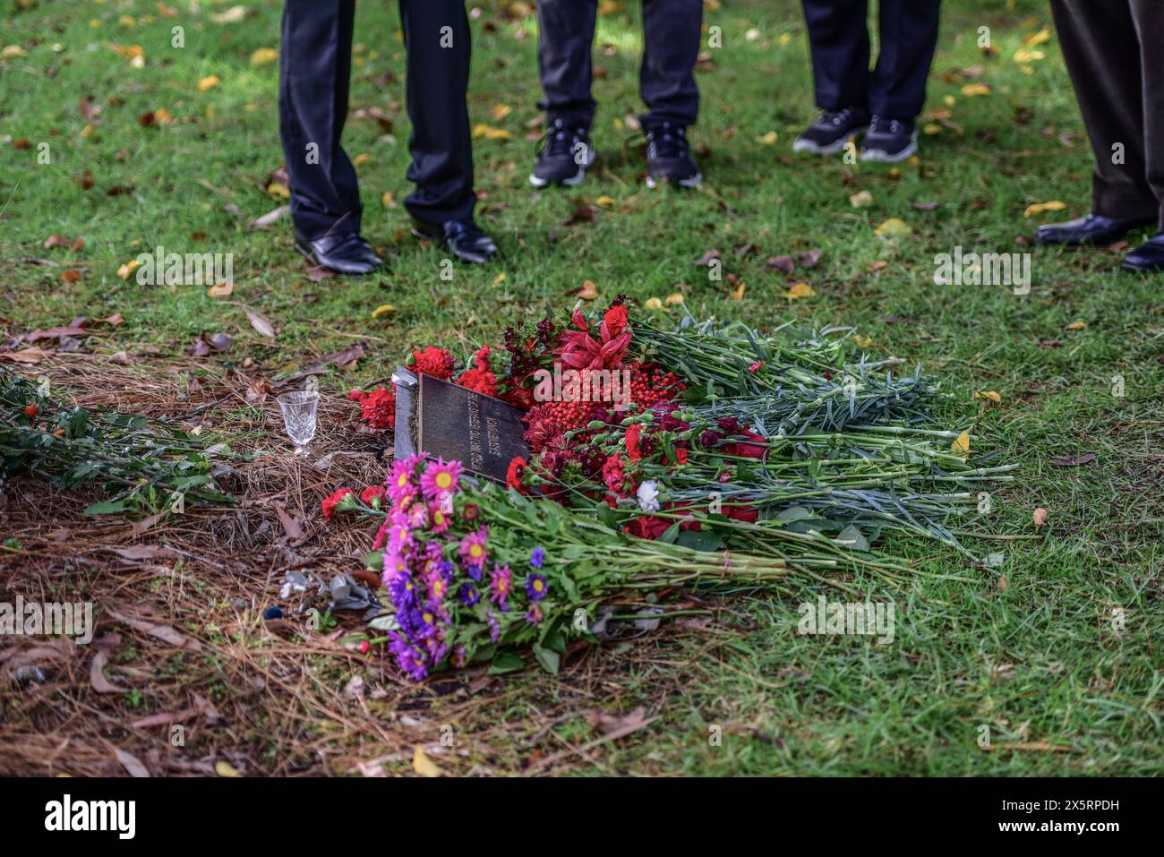 Flowers are laid to the stone commemorating World War 2 veterans from ...