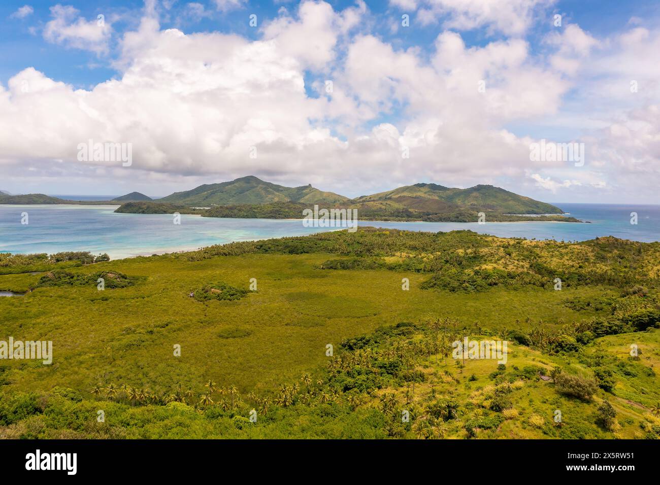 Tropical Fiji island with palm trees and clear blue-green water with ...