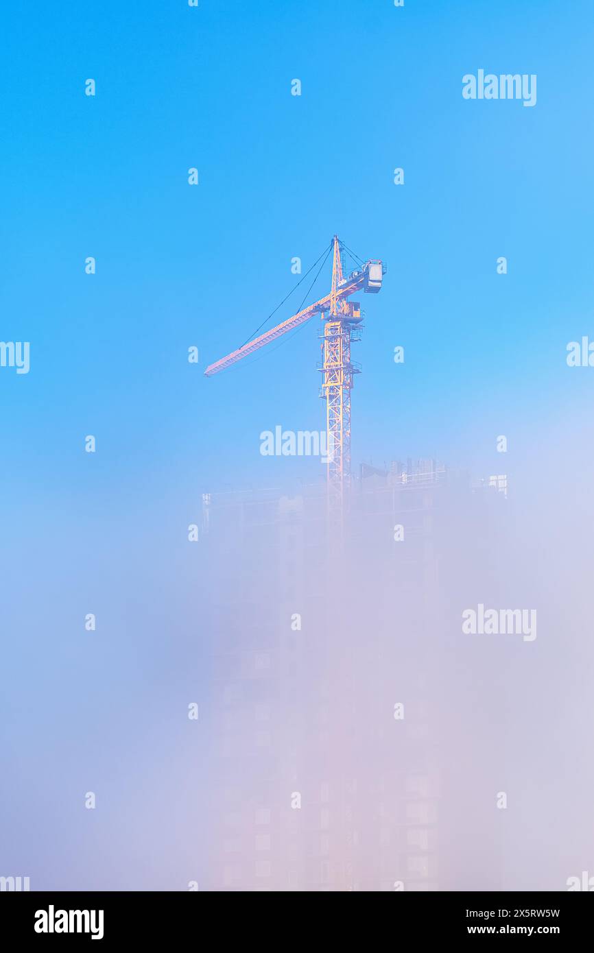 Construction crane in heavy fog. Building a house Stock Photo - Alamy