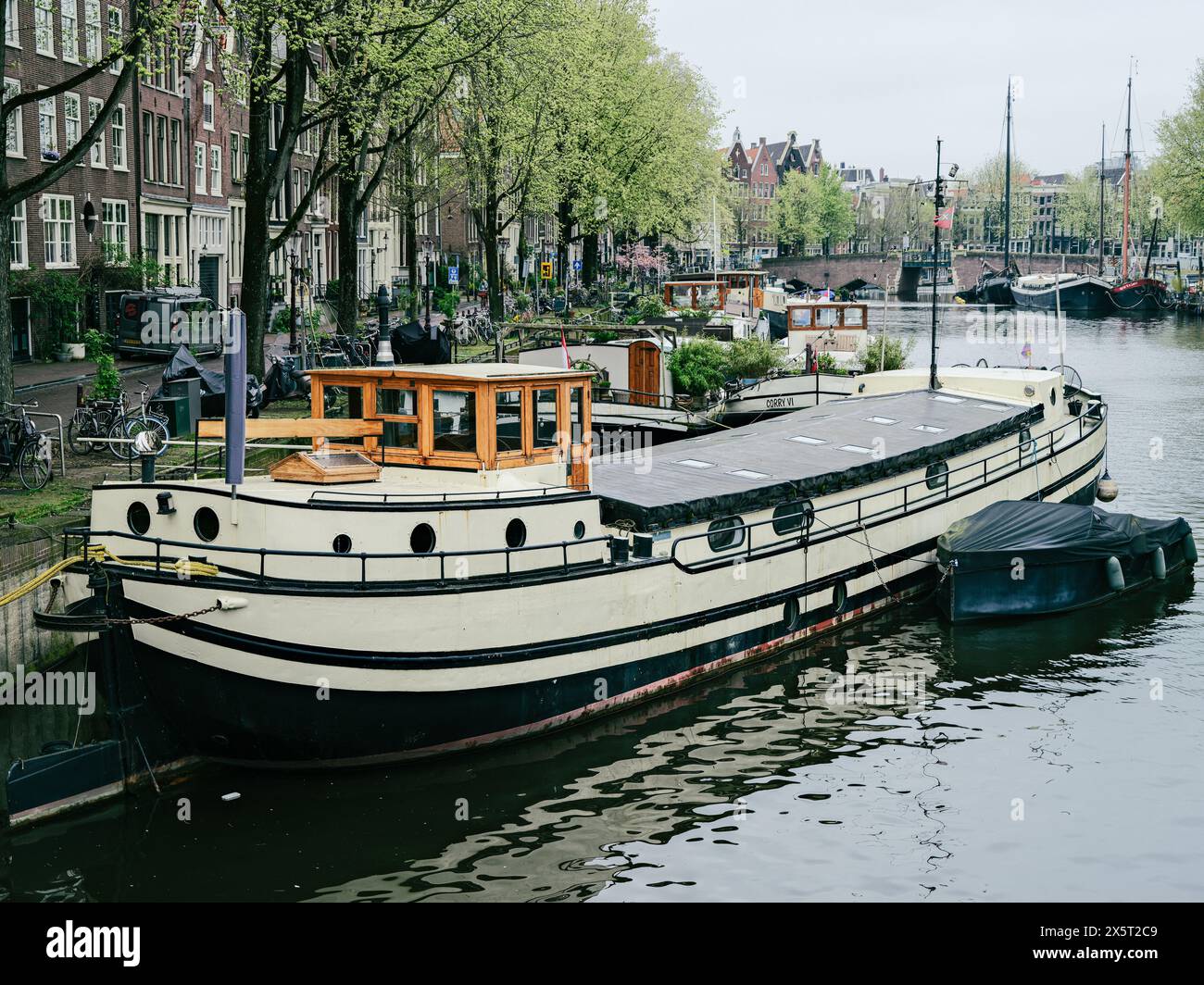 In Springtime in Amsterdam, a row of houseboats enjoy the surroundings ...