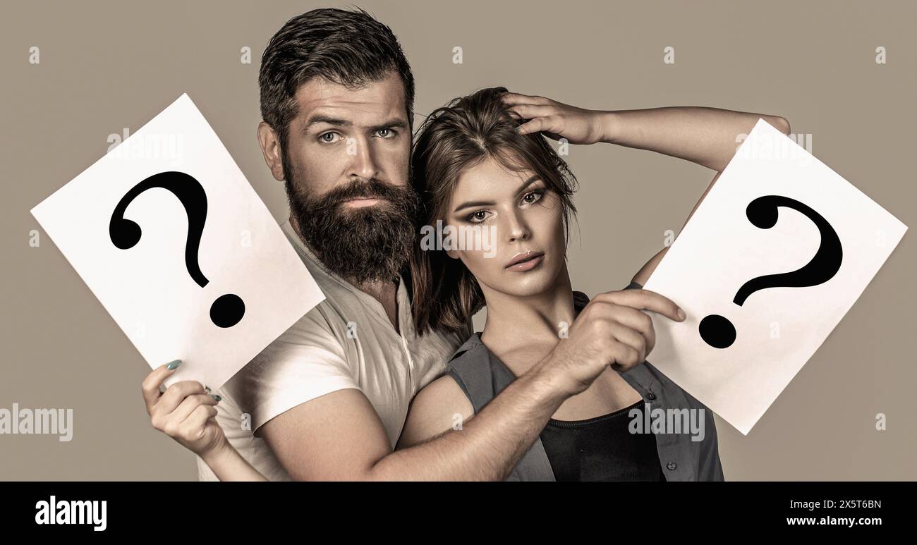 Confused couples with question marks. Portrait of couple holding paper ...