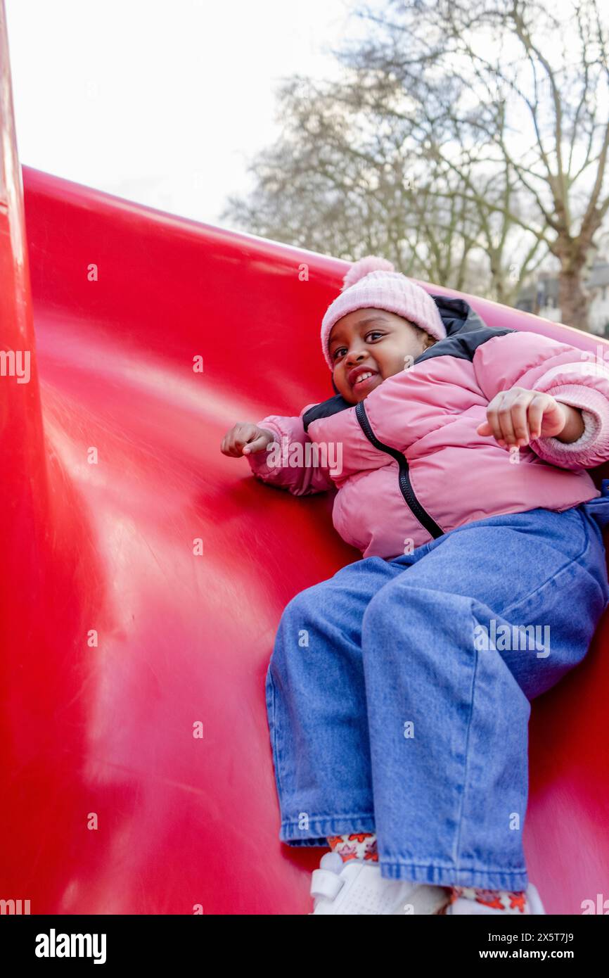 Girl (2-3) going down on slide in playground Stock Photo - Alamy