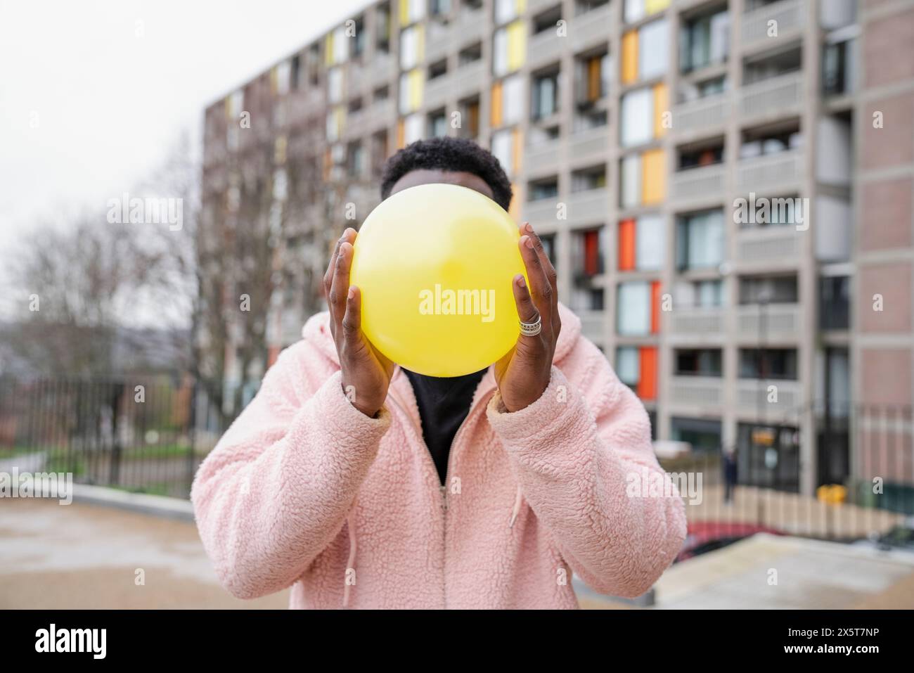 Young man holding balloon in front of face Stock Photo - Alamy