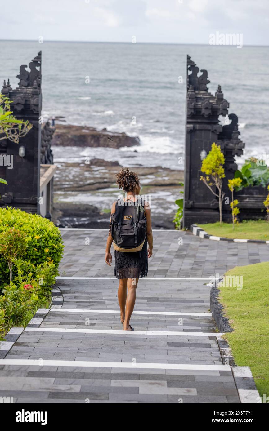 Bali, Indonesia, Rear view of female tourist walking in sea direction ...