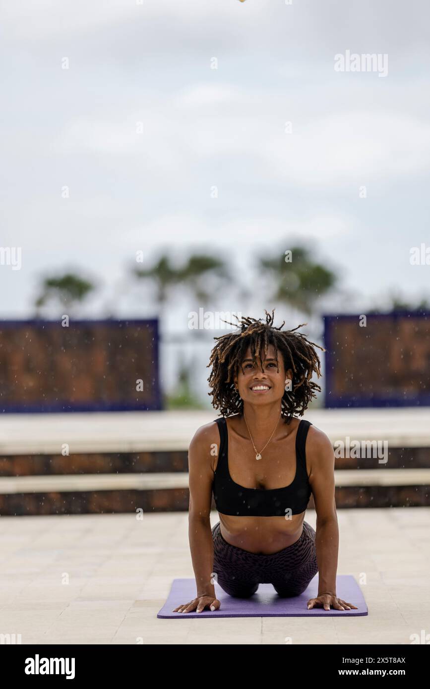 Smiling woman practicing upward facing dog pose Stock Photo - Alamy