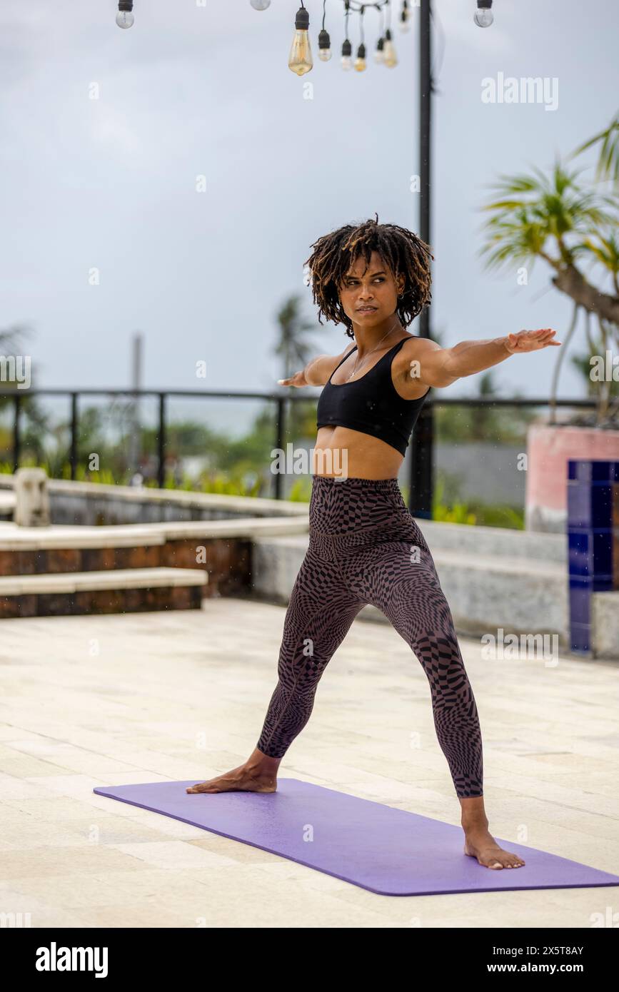 Woman in Virabhadrasana II pose on terrace Stock Photo - Alamy