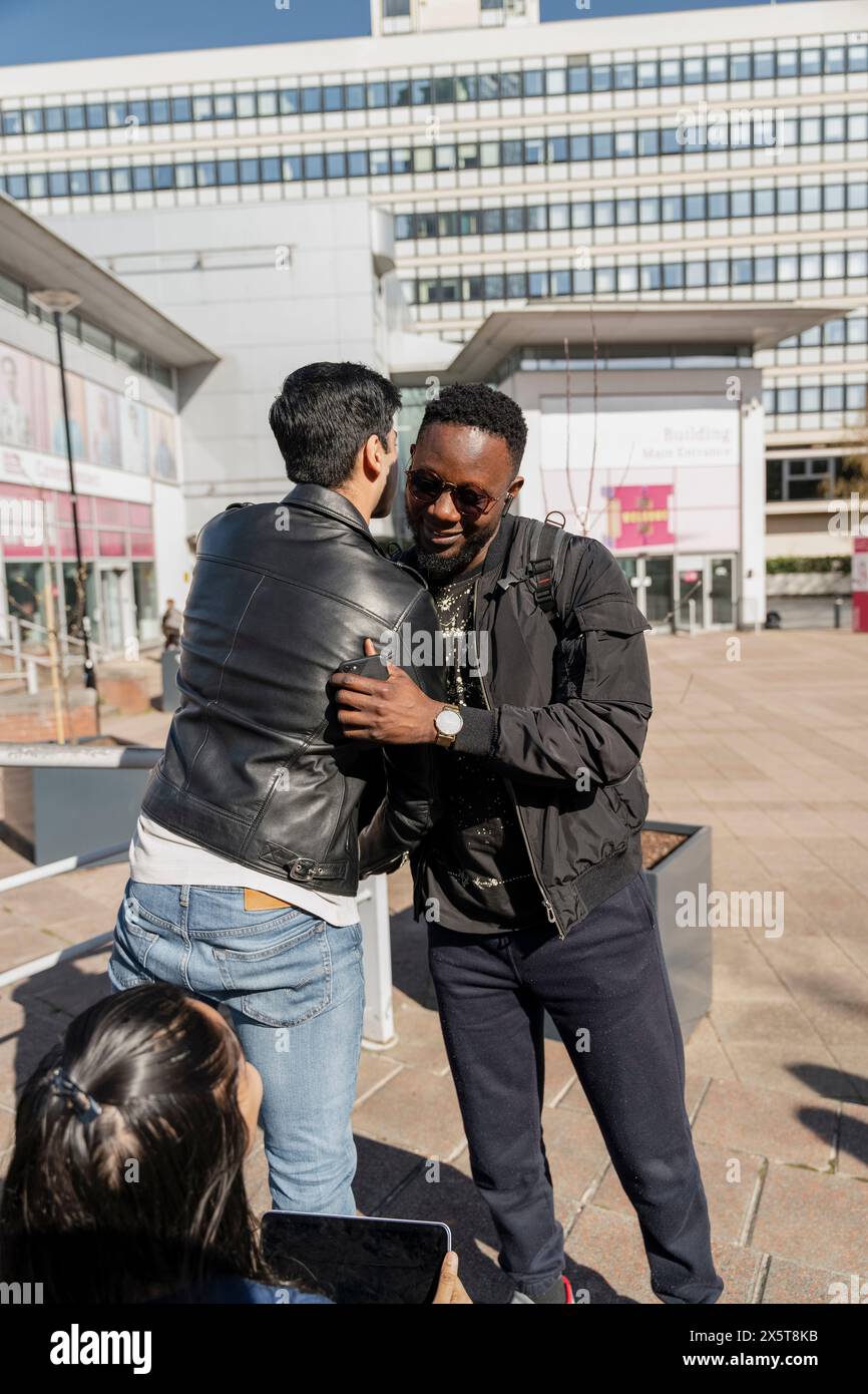 Student friends greeting each other on campus Stock Photo - Alamy