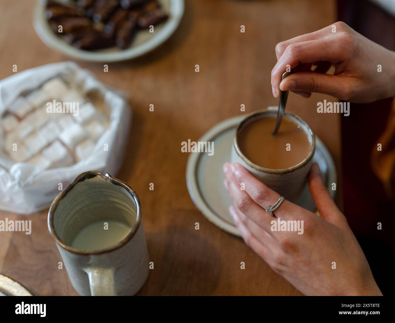 Woman stirring tea with milk Stock Photo - Alamy