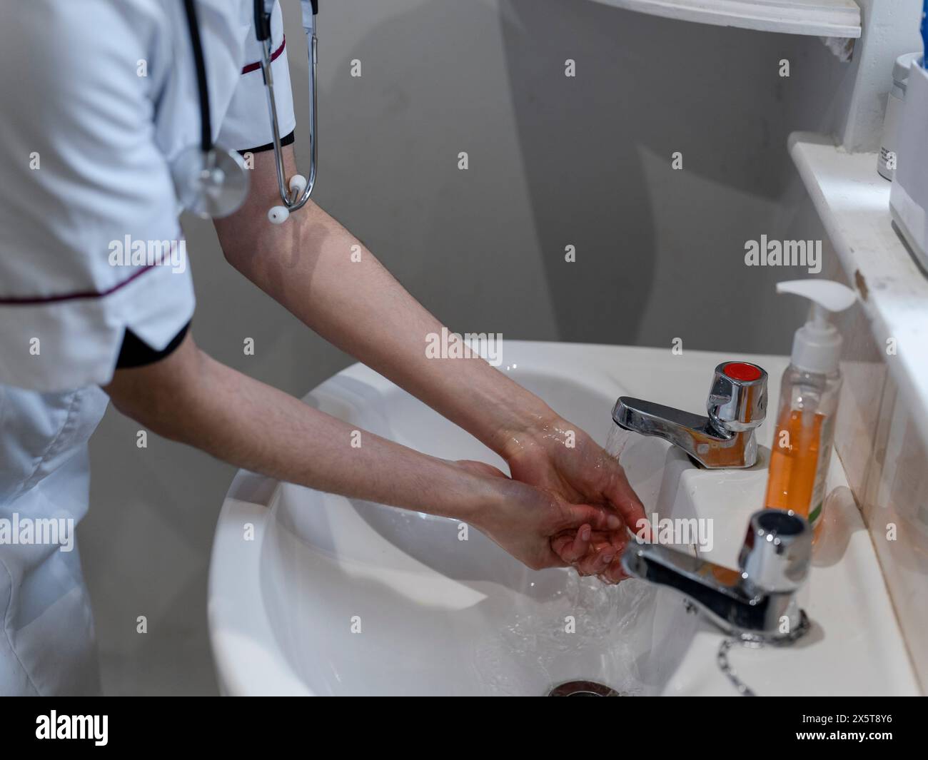Doctor washing hands in sink Stock Photo - Alamy
