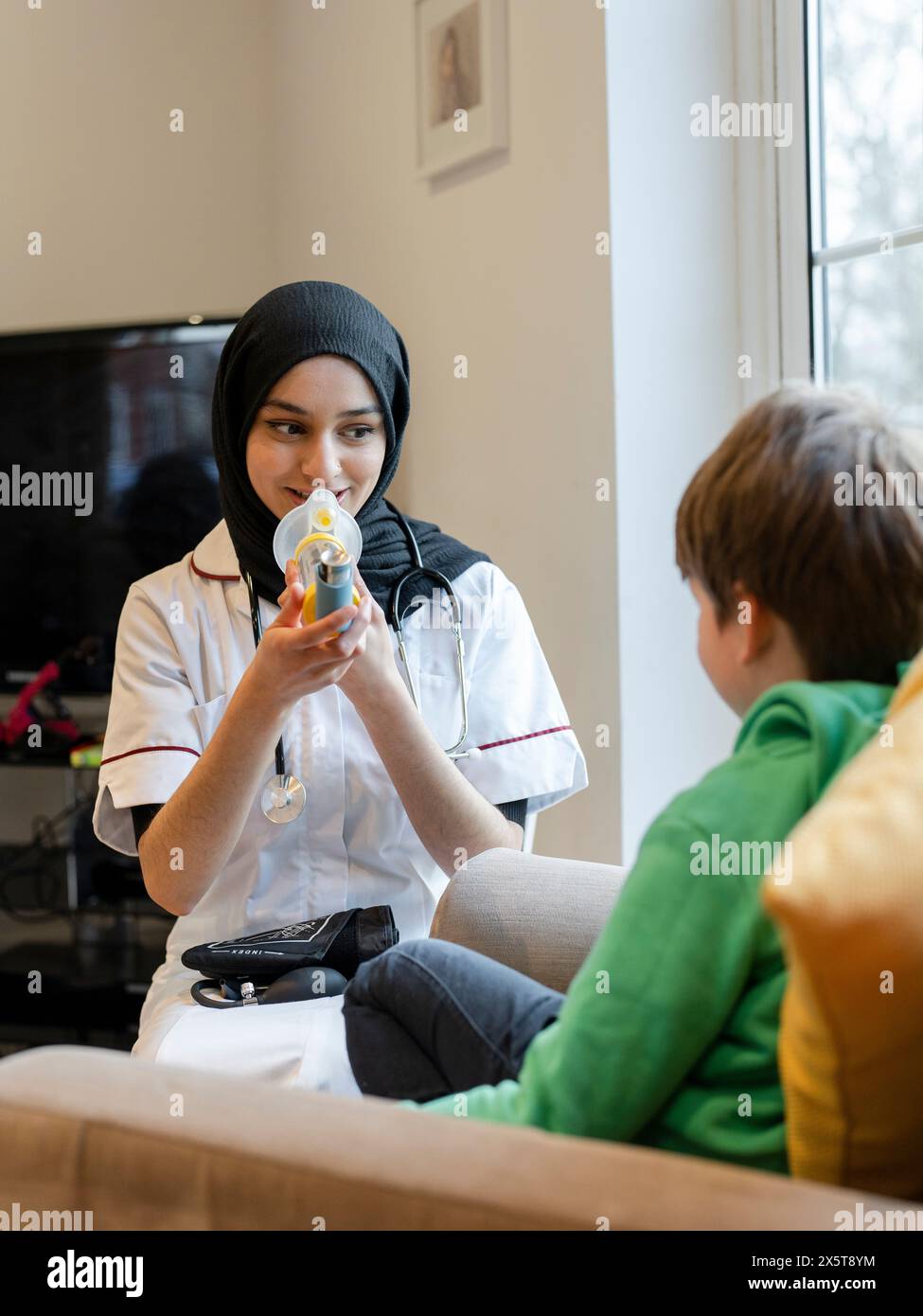 Female doctor demonstrating to boy how to use inhaler Stock Photo - Alamy