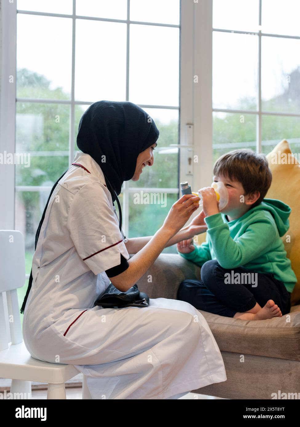 Doctor assisting boy using inhaler Stock Photo - Alamy