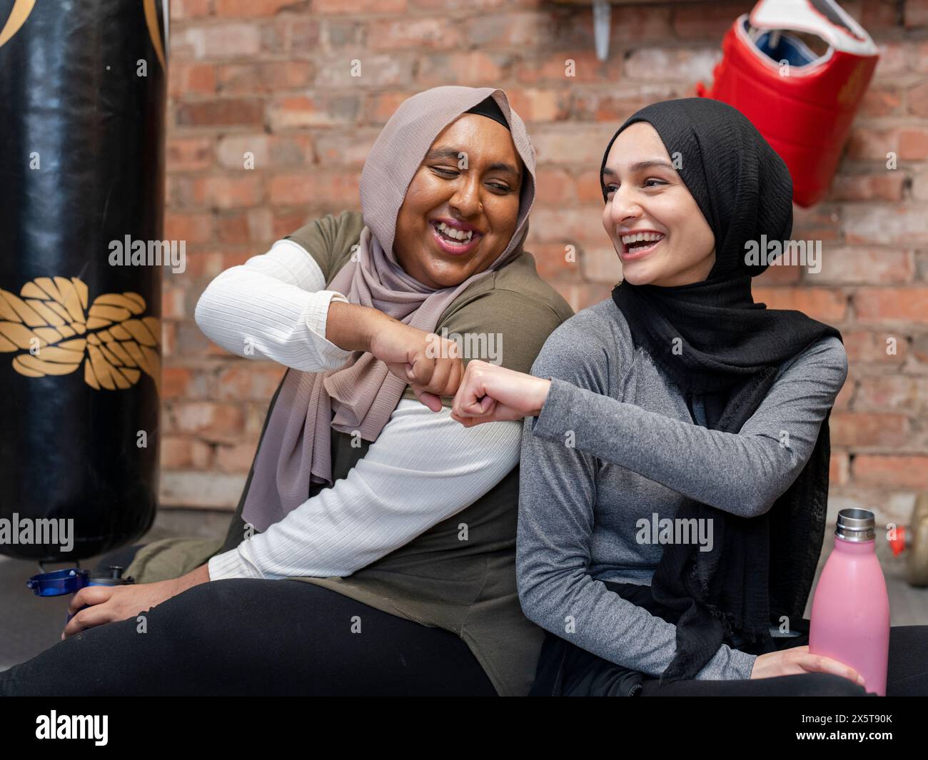 Smiling women doing fist bump in gym Stock Photo - Alamy