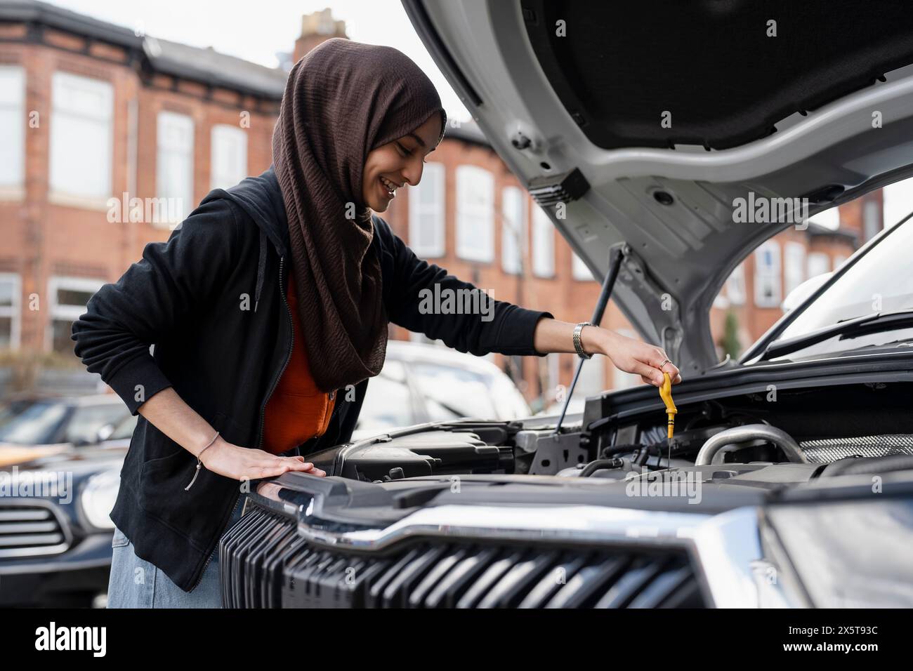 Woman wearing hijab checking oil in car engine Stock Photo - Alamy