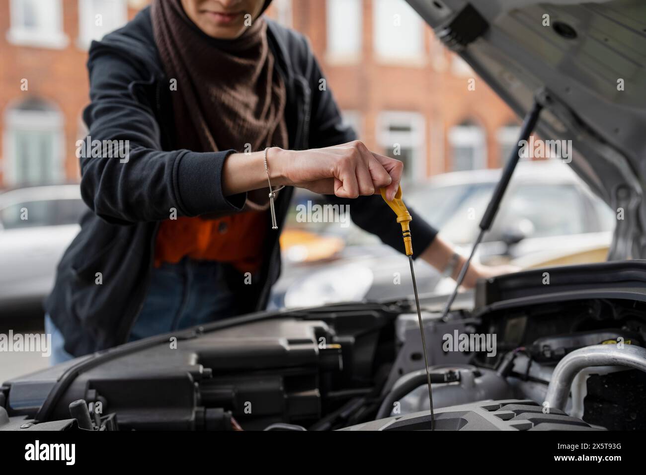 Woman checking oil in car engine Stock Photo - Alamy