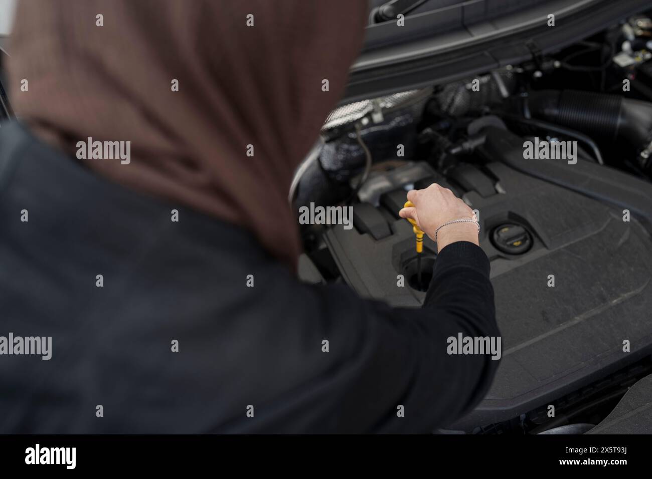 Woman wearing hijab checking oil in car engine Stock Photo - Alamy