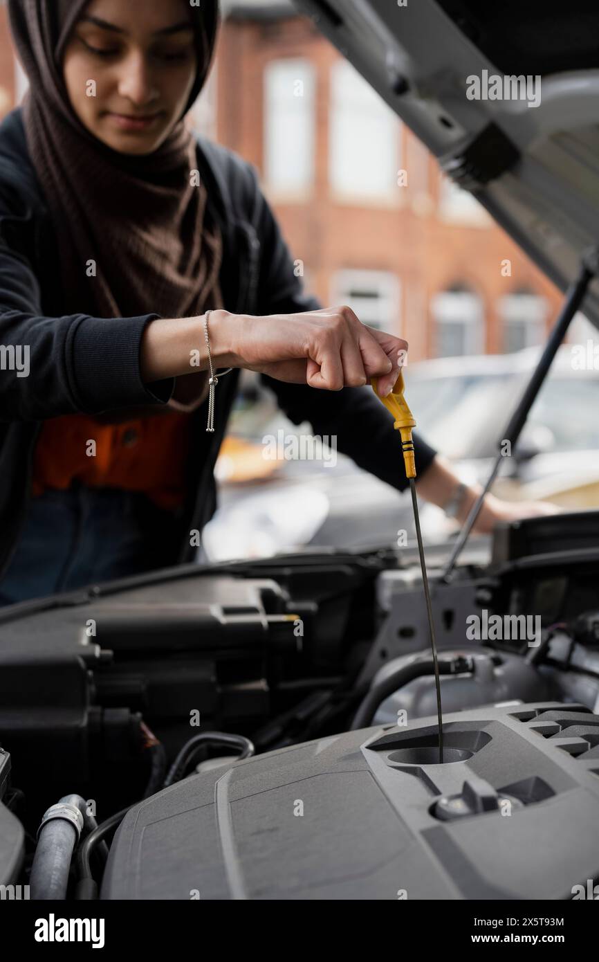 Woman wearing hijab checking oil in car engine Stock Photo - Alamy